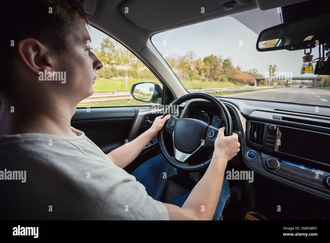 Focused young man driving car confident. Teenager driver enjoying the ...