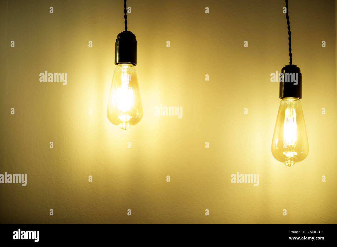 A burning light bulb glows faintly against the background of blurry ...