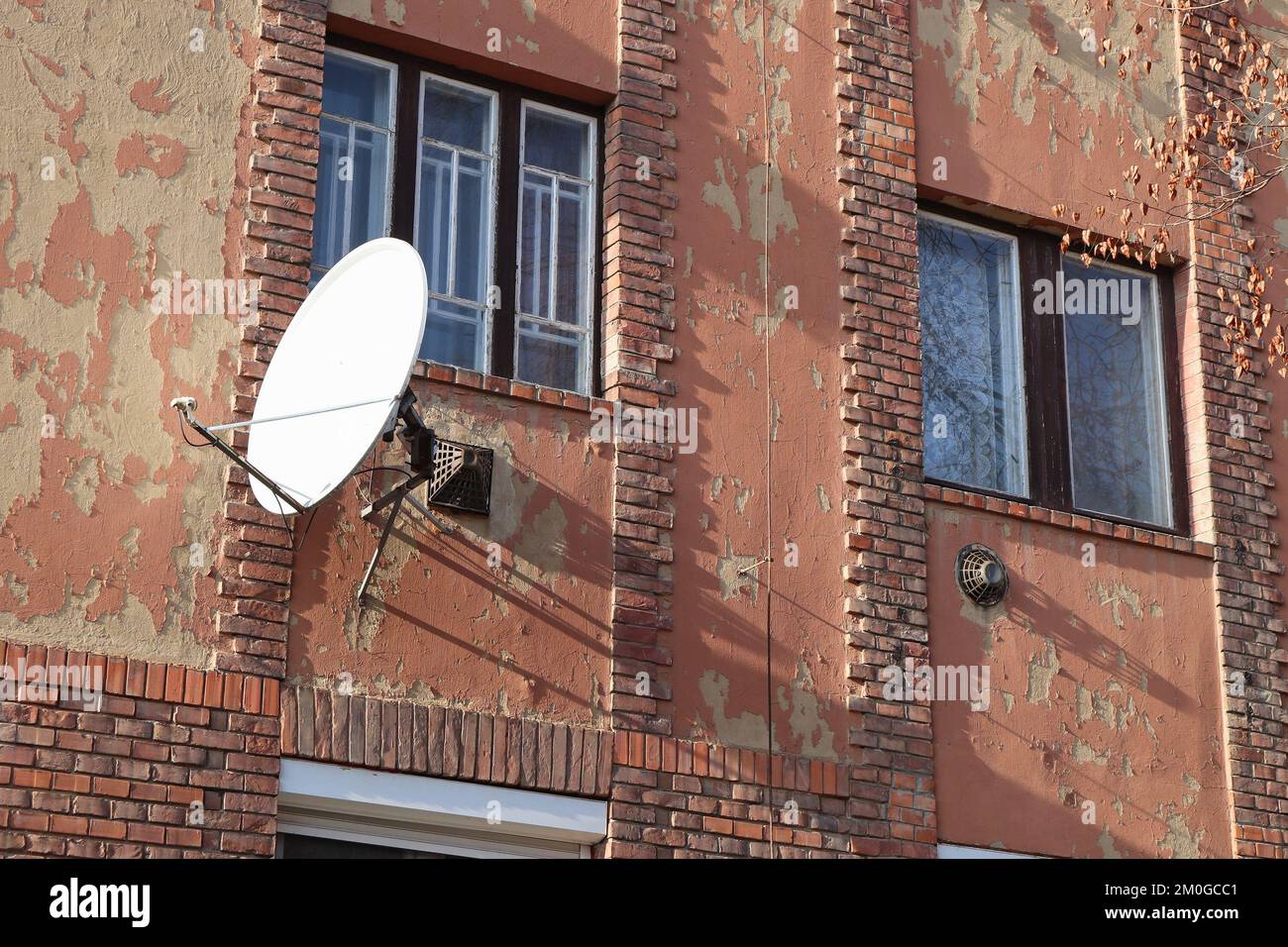 Satellite dish on the wall of an old apartment building Stock Photo - Alamy