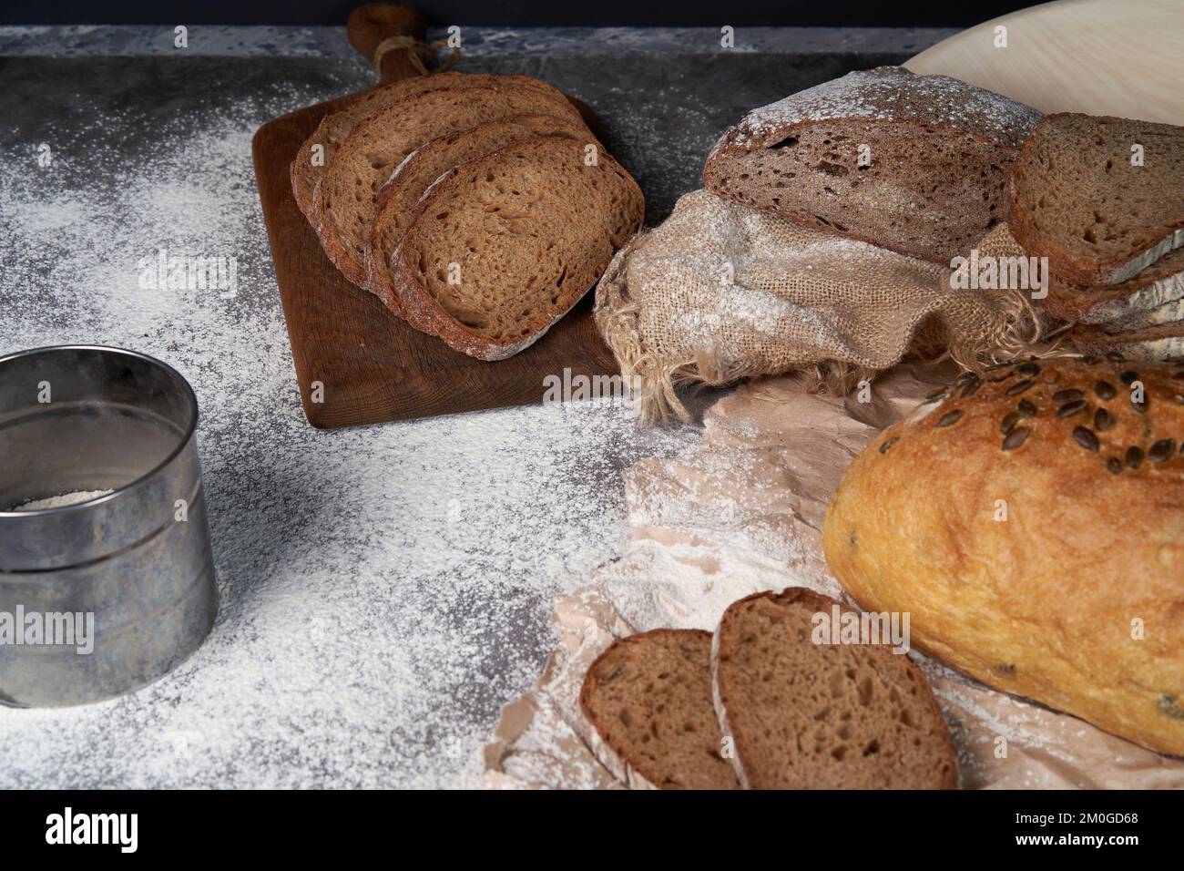 Different types of sliced bread and a loaf on a wooden background ...