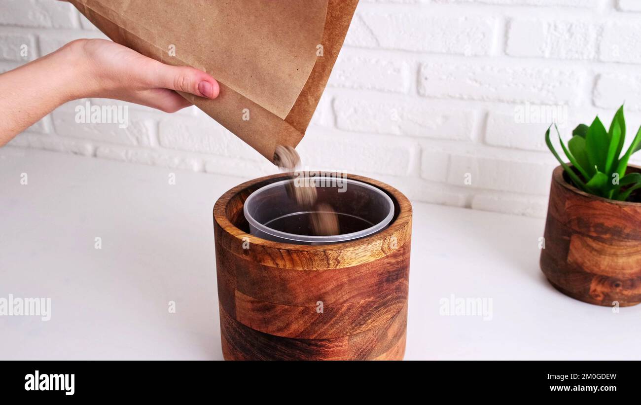 Woman gardener pours drainage for planting a houseplant in a pot, home ...