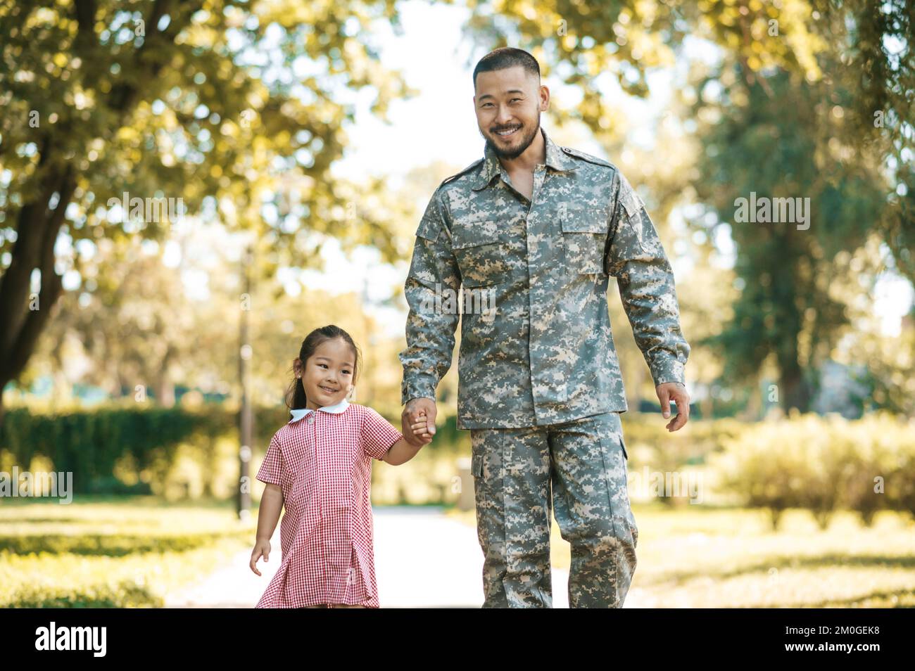 Military man walking with his littile daughter in the park Stock Photo ...