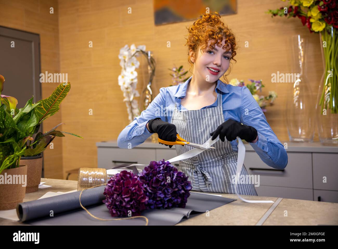 Cute ginger florist looking involved while making a cover for the ...