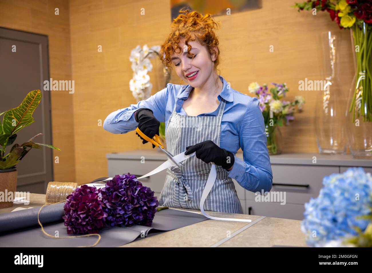 Cute ginger florist looking involved while making a cover for the ...