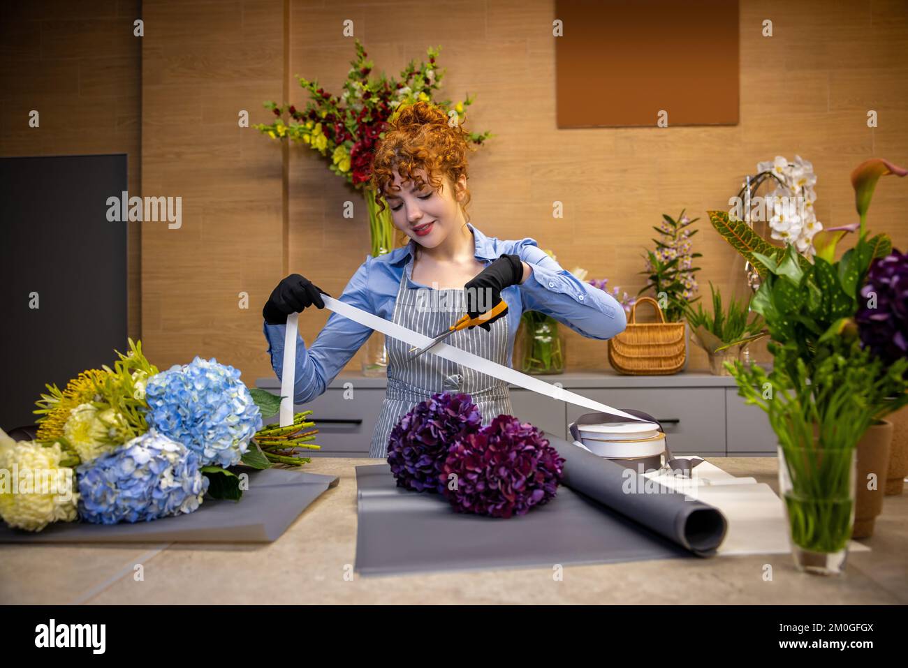 Cute ginger florist looking involved while making a cover for the ...