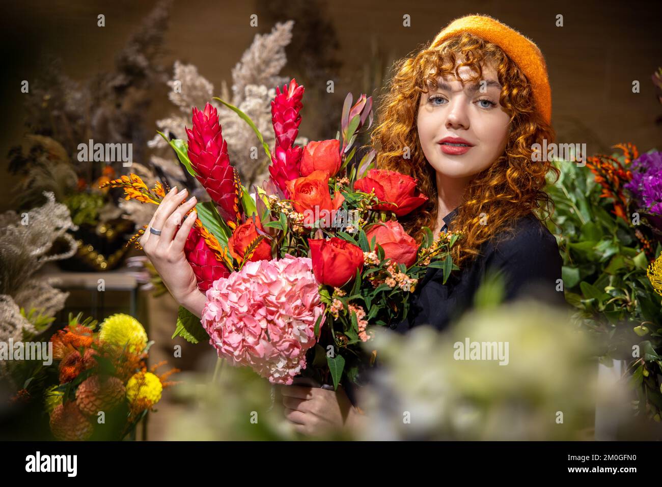 Pretty girl in an orange beret in a flower shop Stock Photo - Alamy
