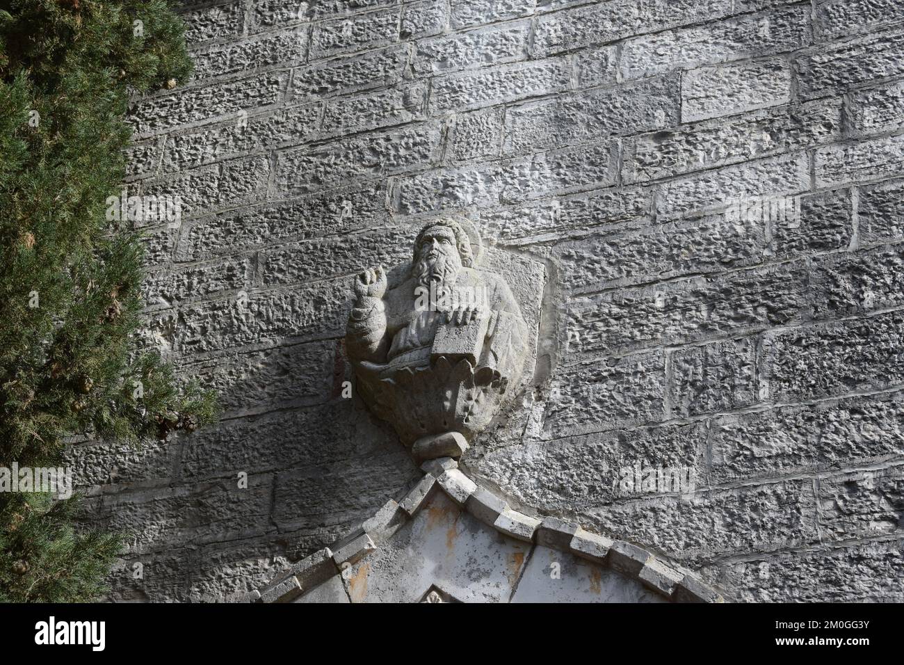 A stole marble statue in the wall of a Christian holding bible Stock ...