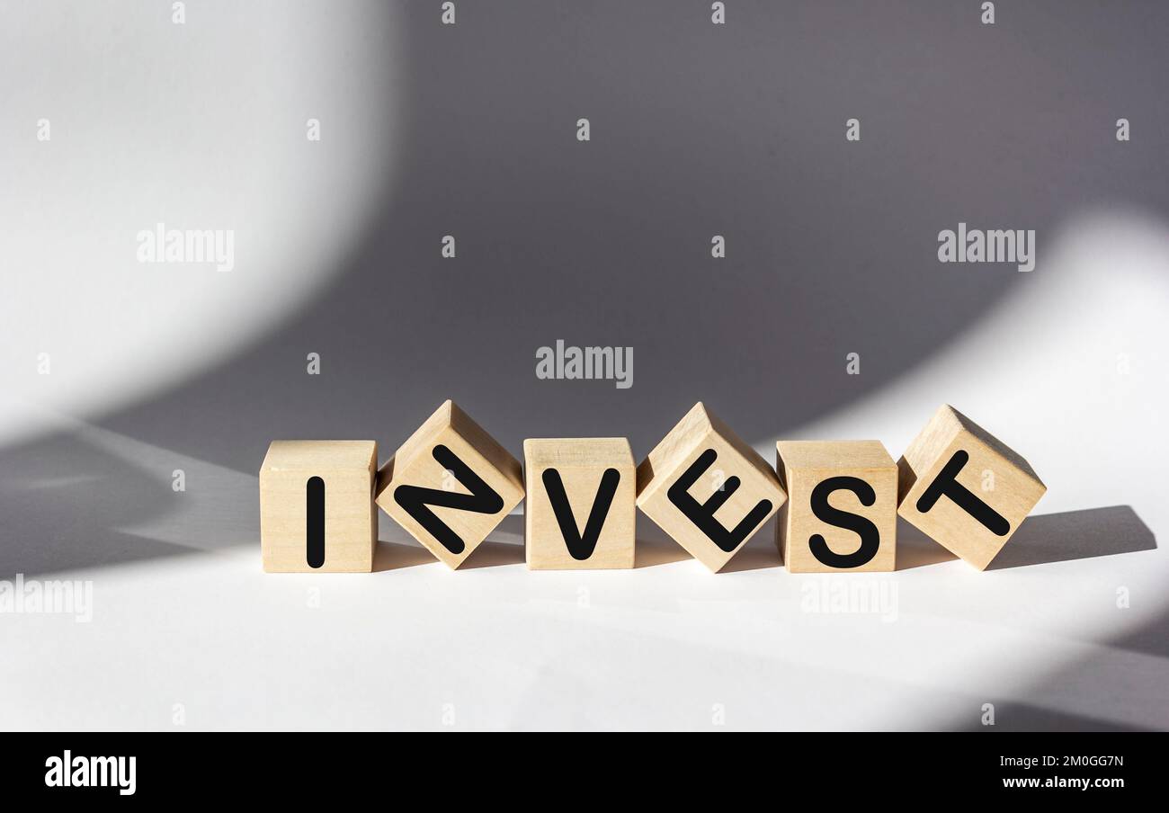 The word invest in wooden cubes on a white vintage background ...