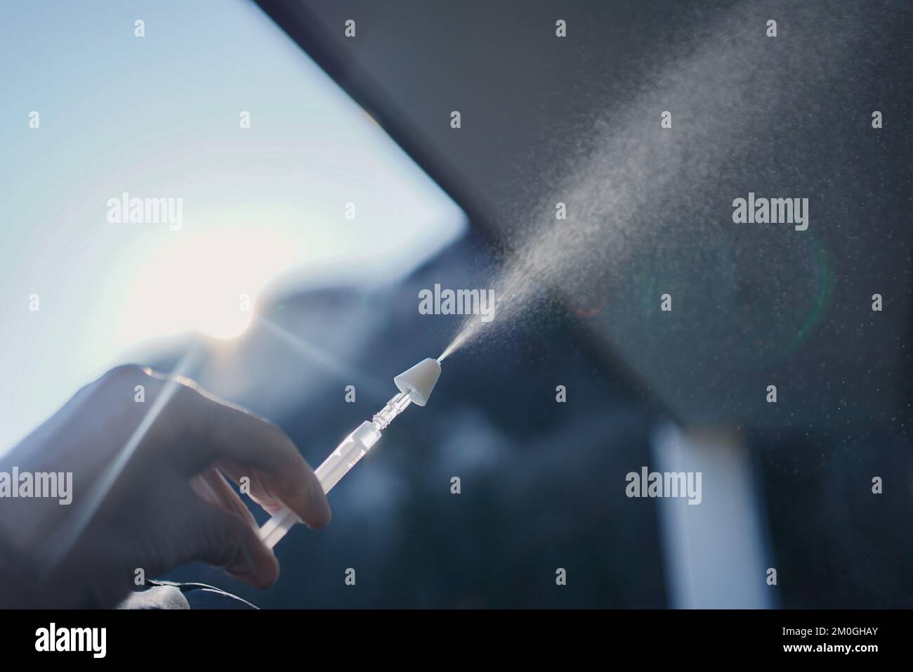 Hand using a syringe with a mucosal atomization decive (MAD) for ...