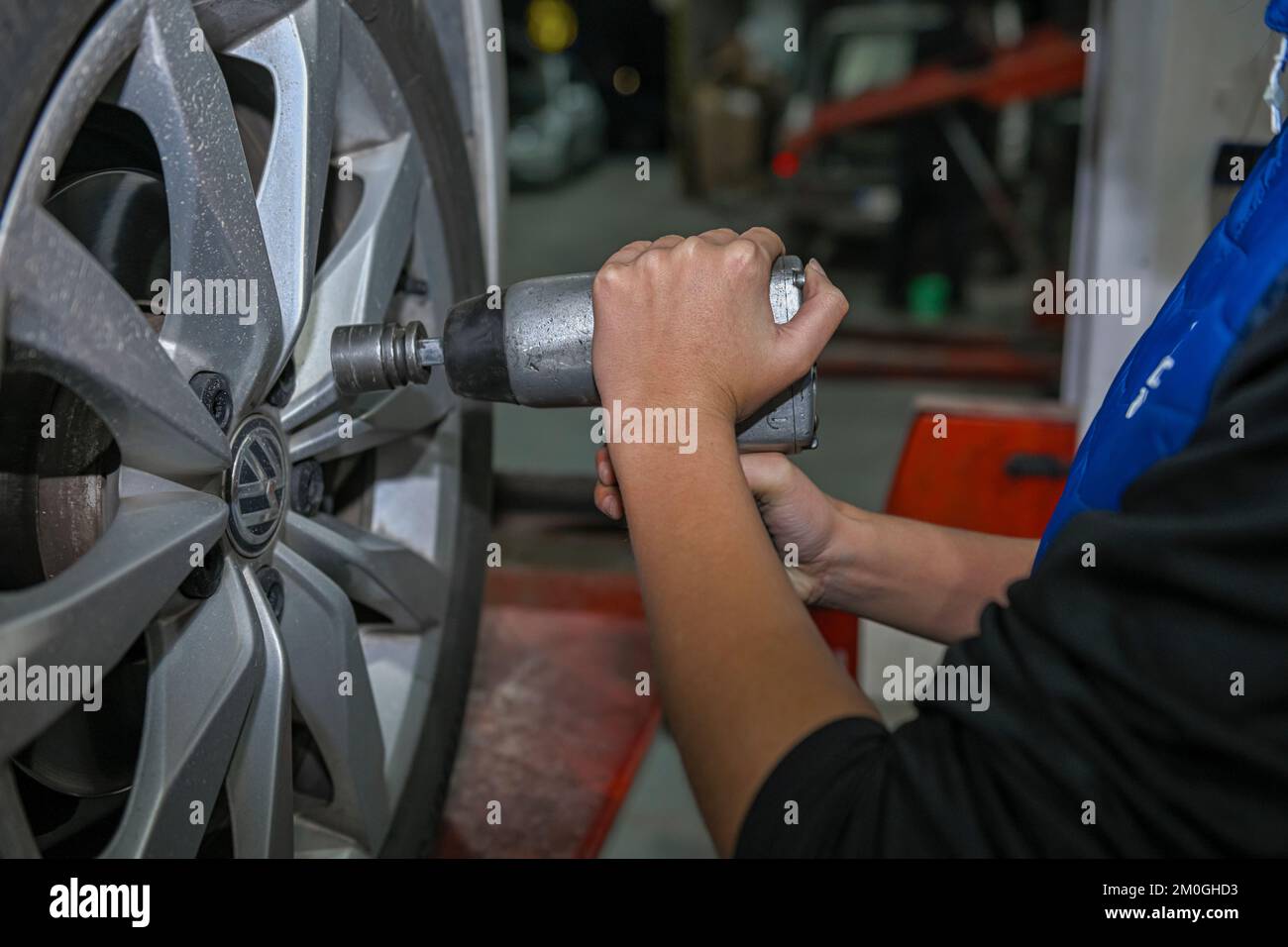 Female hands removing the bolts from a wheel for repair Stock Photo - Alamy