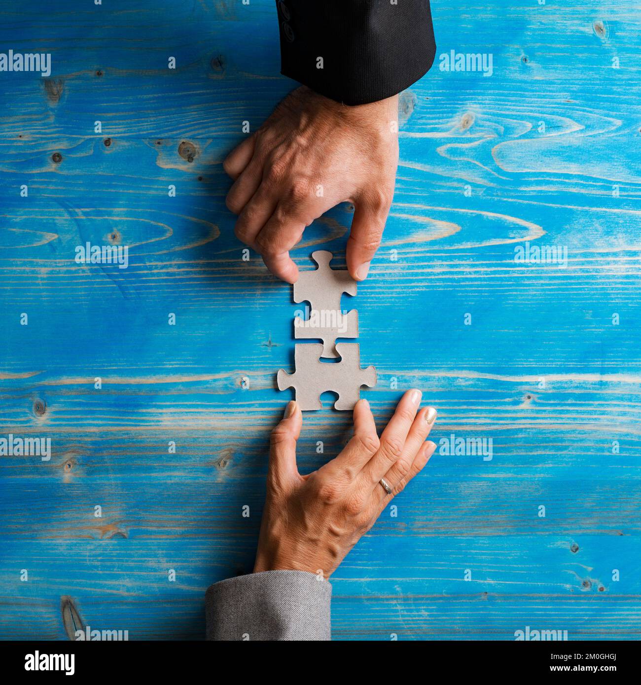 Top view of male and female hands in a suit matching and joining two ...