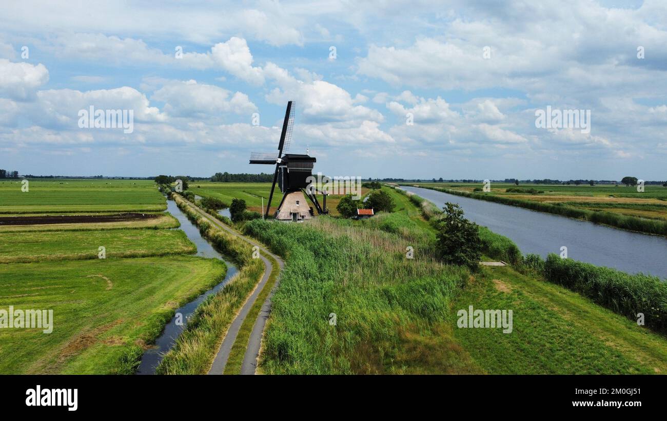 A windmill near the rivers in a farmland Stock Photo - Alamy