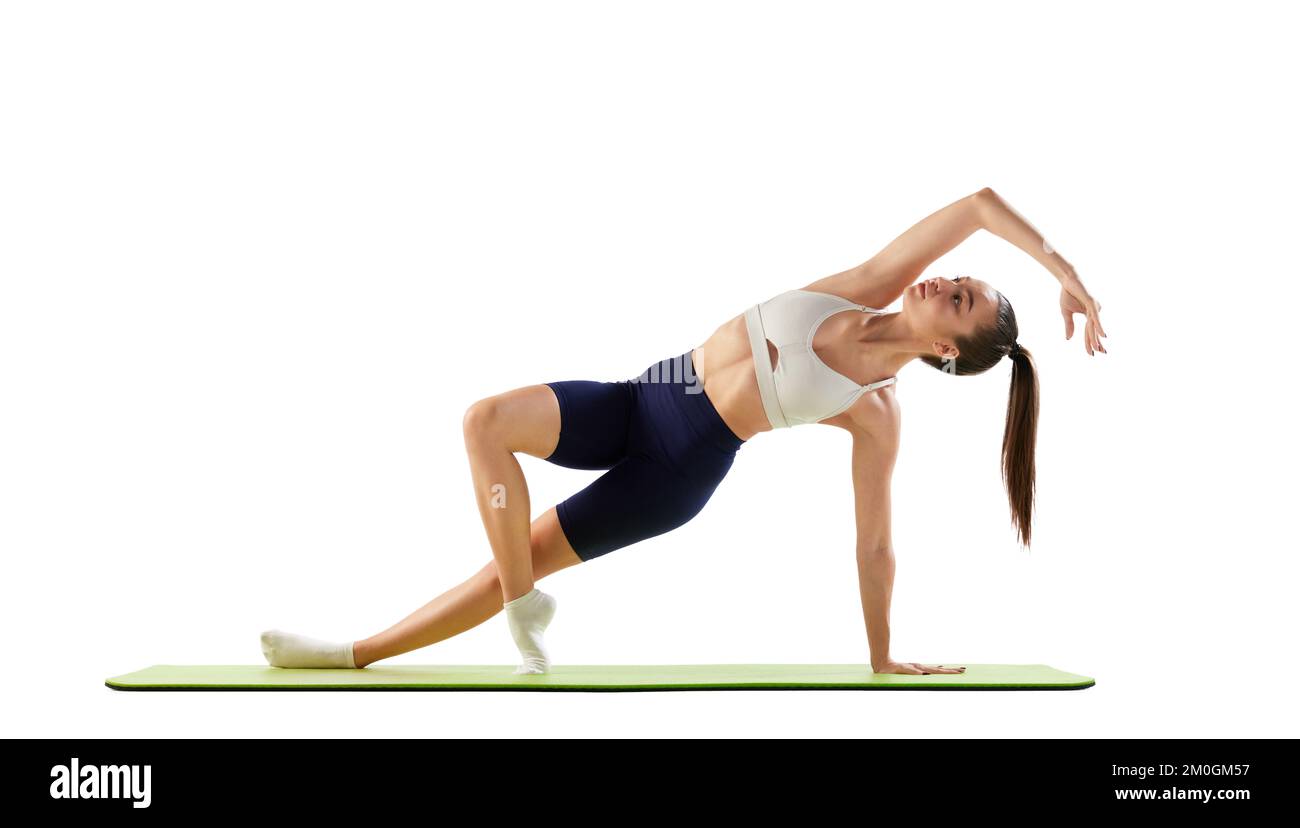 Portrait of young sportive woman training, doing stretching exercises ...