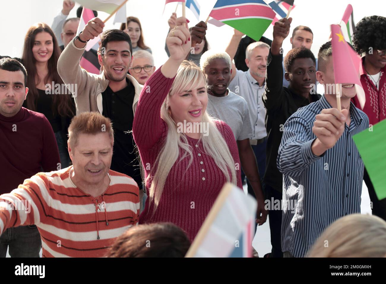 group of different people with their national flags striding forward ...