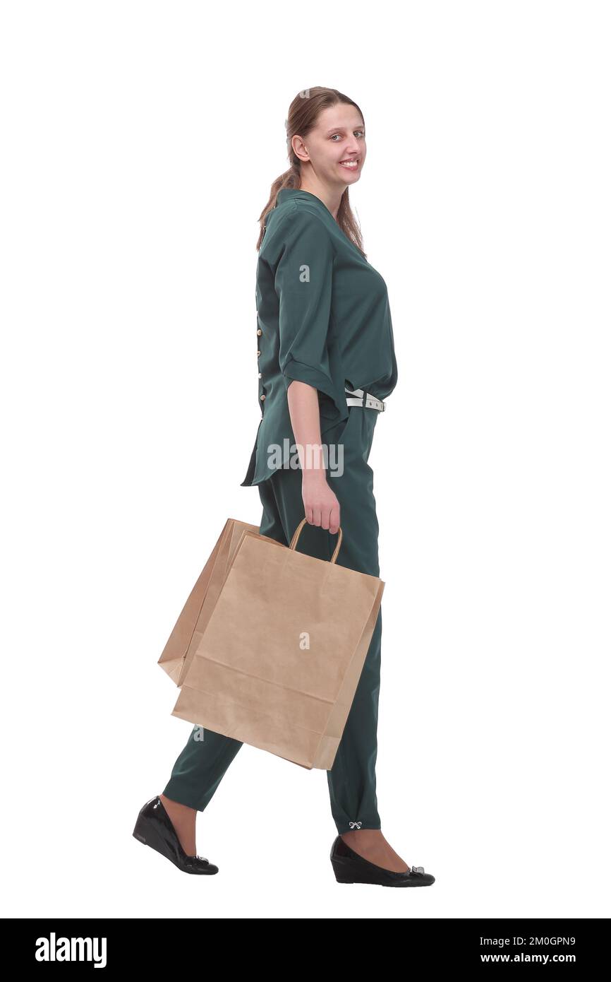 Full length side view of happy young woman walking with shopping bags ...