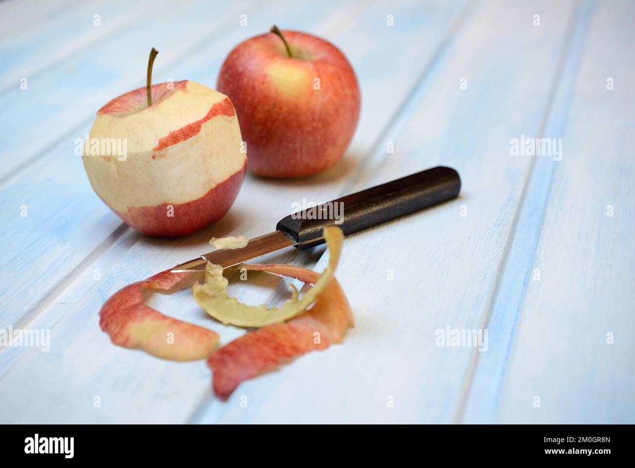 Peeled apple with peeling knife, apple peels Stock Photo - Alamy