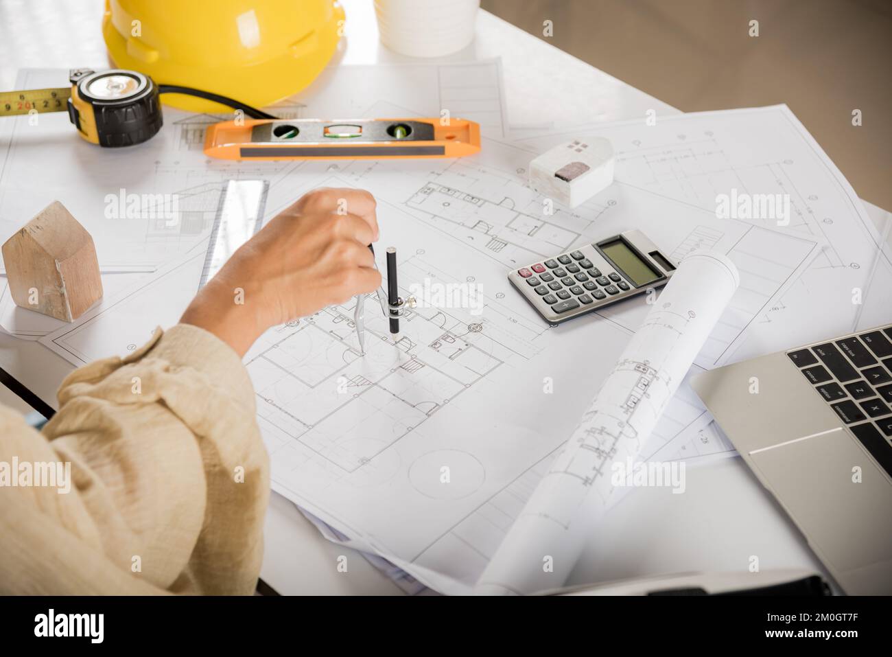 Architect drawing with divider compass on house plan blueprint paper ...