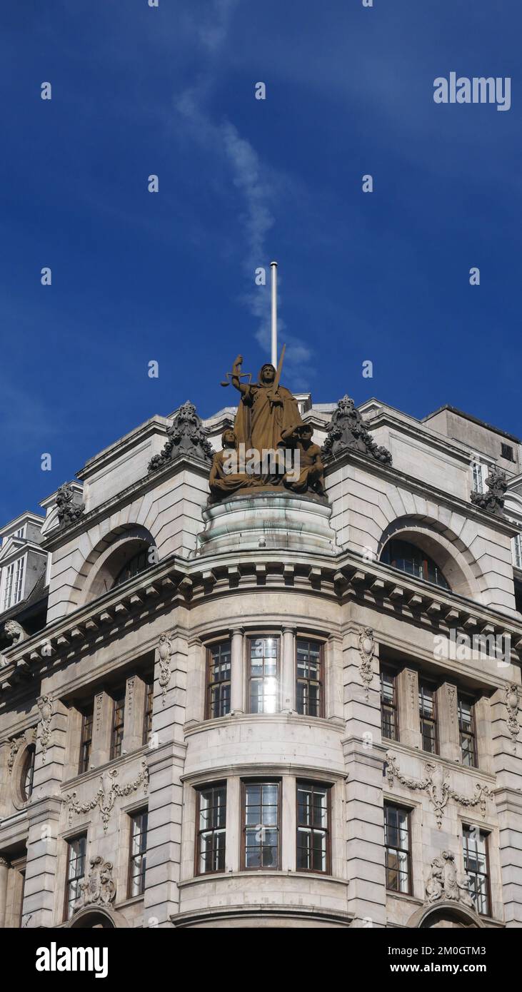 A low angle shot of statue of Justice on top of building on corner of ...