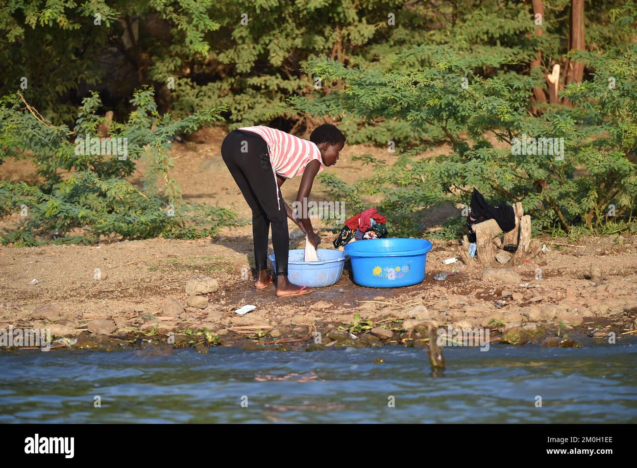 Young woman washing clothes at a lake in Kenya Stock Photo - Alamy
