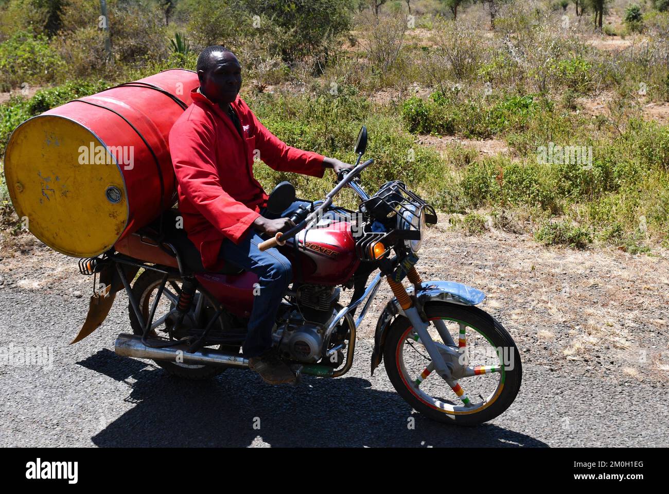 Man rides oil barrel on a motorbike in Kenya Stock Photo - Alamy