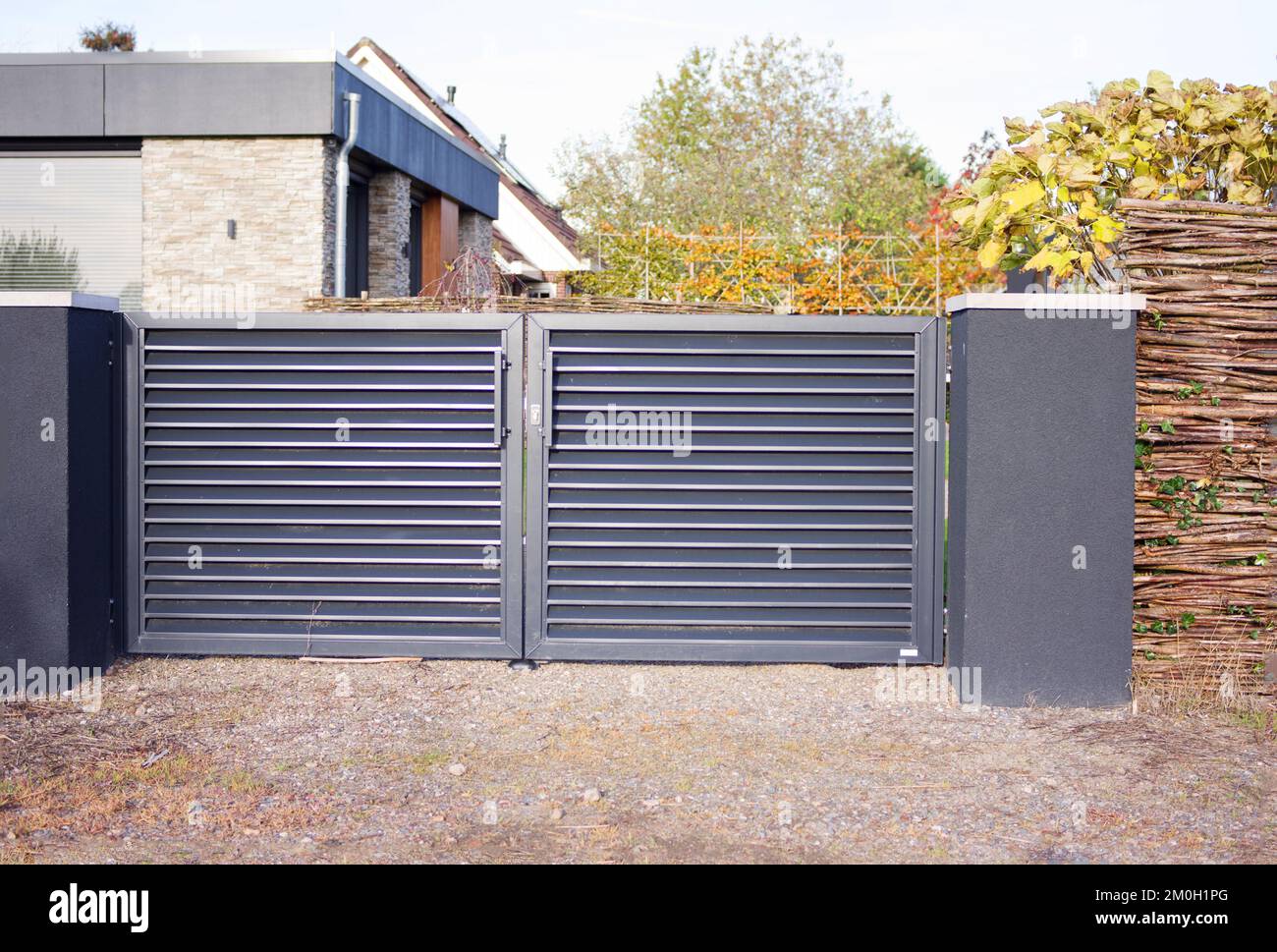 Closed modern grey gate that protect a property Stock Photo - Alamy