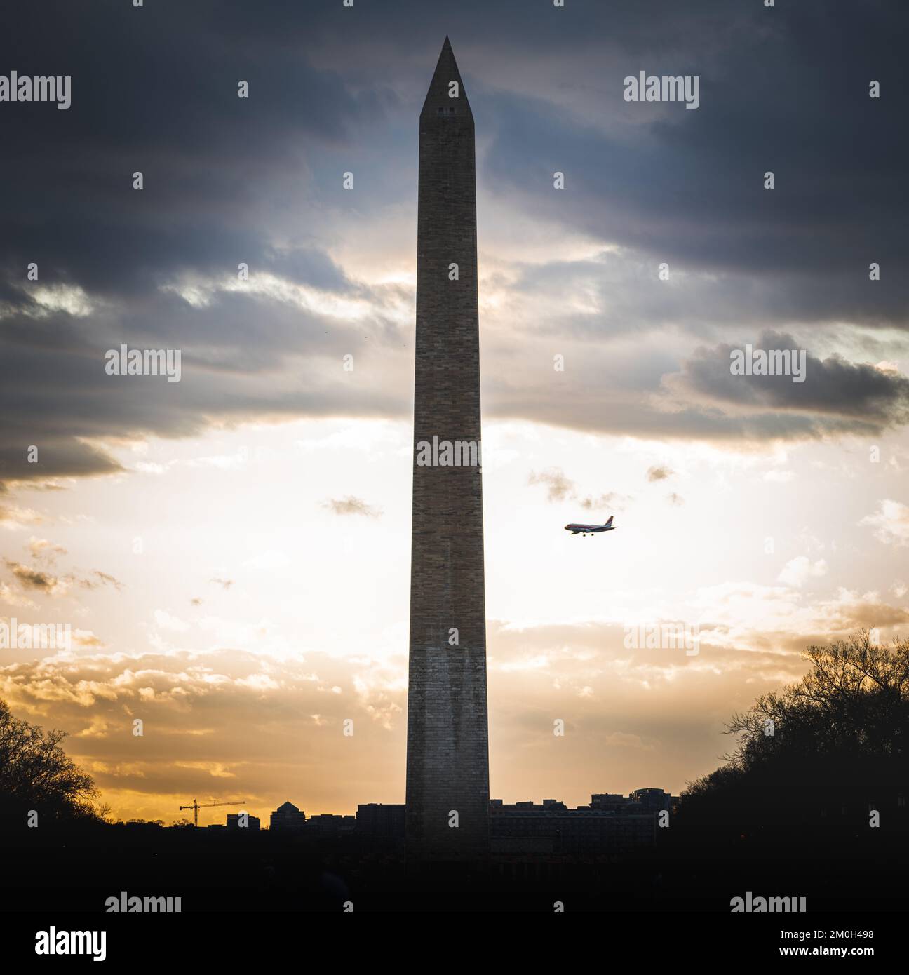 A vertical of Washington monument silhouette at sunset cloudy golden ...