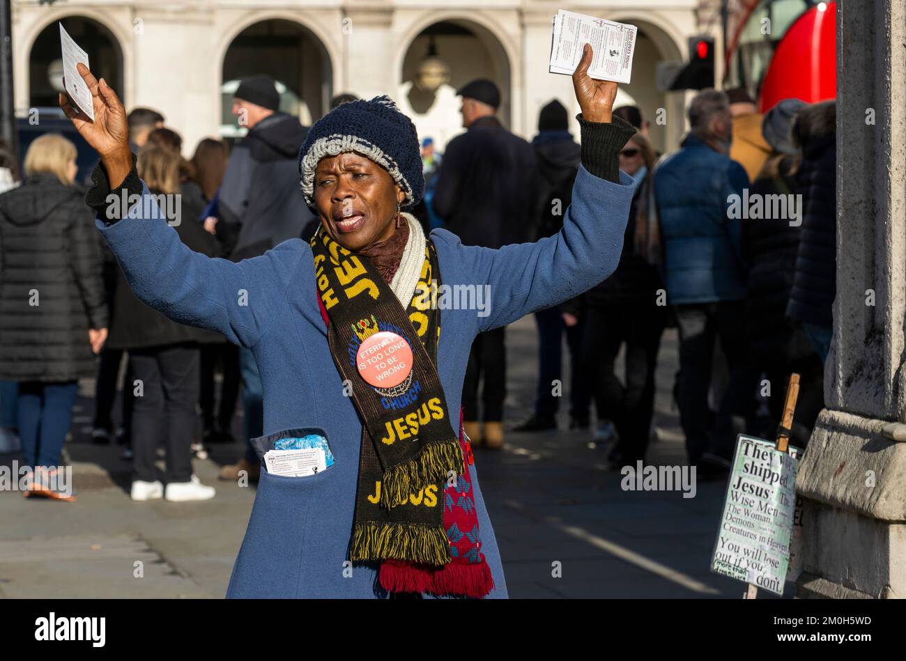 A black woman handing out leaflets about Christianity as she evangelise ...