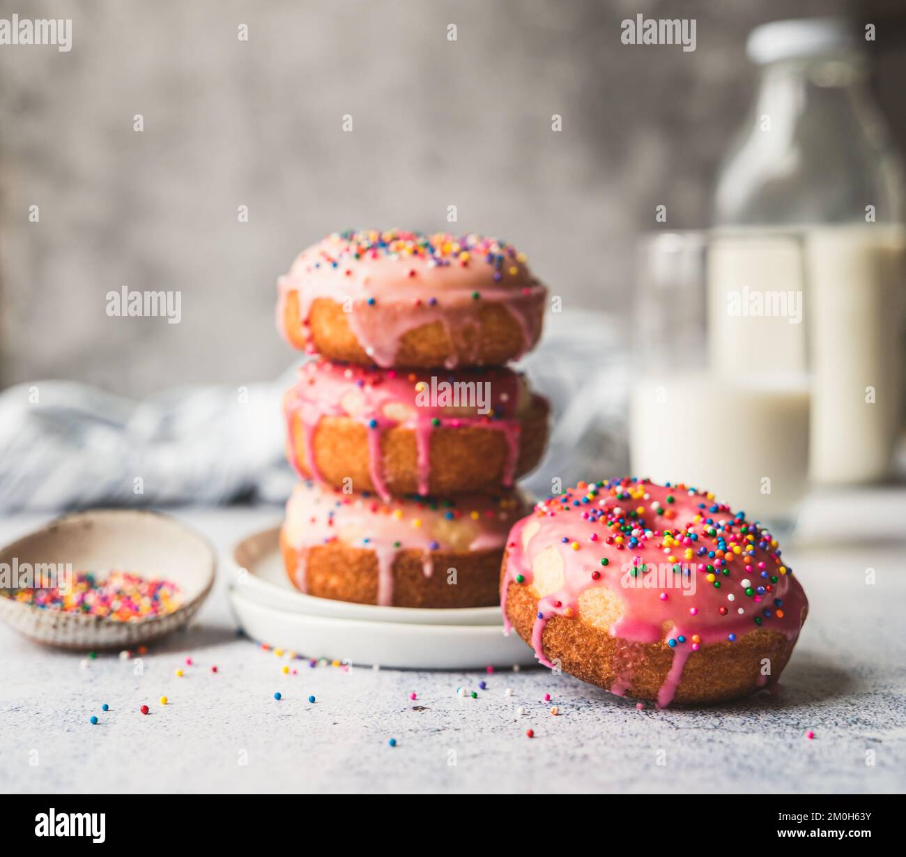 Stack of vanilla cake donuts with pink icing and sprinkles Stock Photo ...