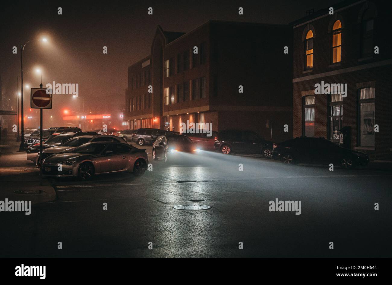 Car driving through a city street on a foggy autumn night Stock Photo ...