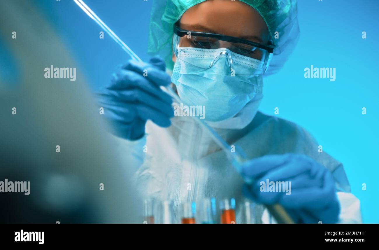 Woman in goggles and mask working with test tubes in laboratory Stock ...