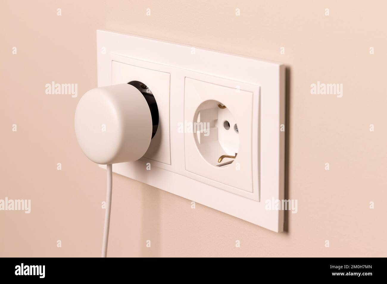 Group of white european electrical outlets with round plug inserted ...