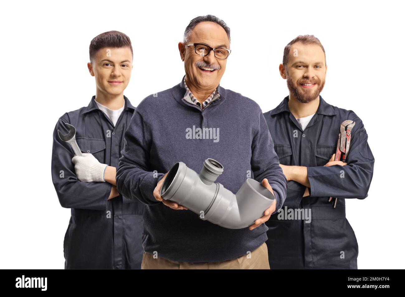 Portrait of a mature man holding a plastic pipe and plumbers standing ...