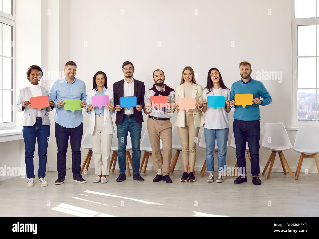 Diverse group of happy people standing in office and sharing opinions ...