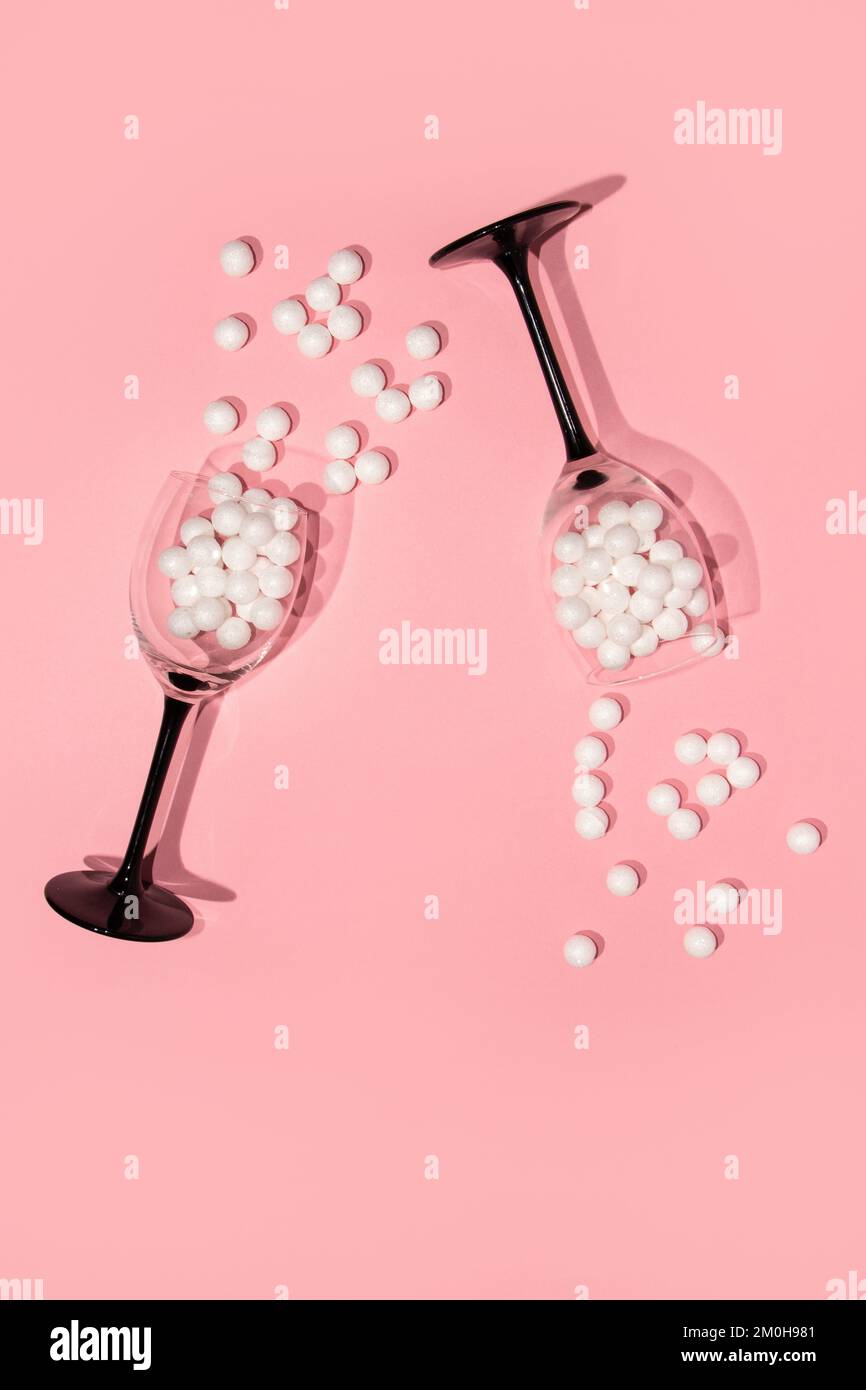 Wine glasses with white shiny beads on pink background. Creative ...