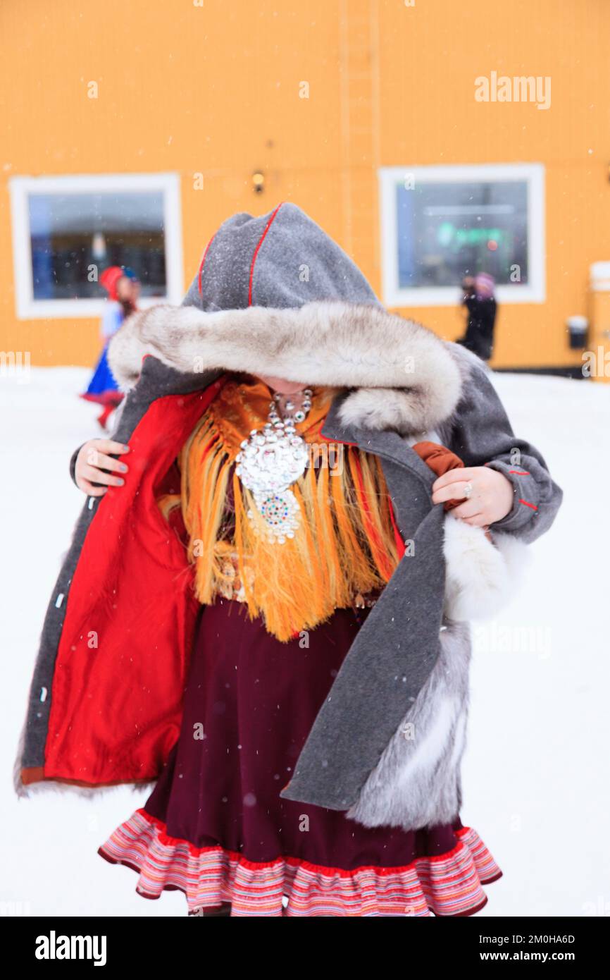 Sweden, Norbotten County, Jokkmokk, Sami woman in costume taking off ...
