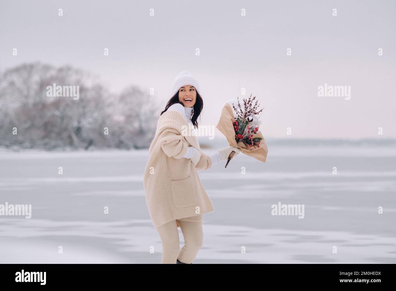 A girl in a beige cardigan and winter flowers walks in nature in the ...