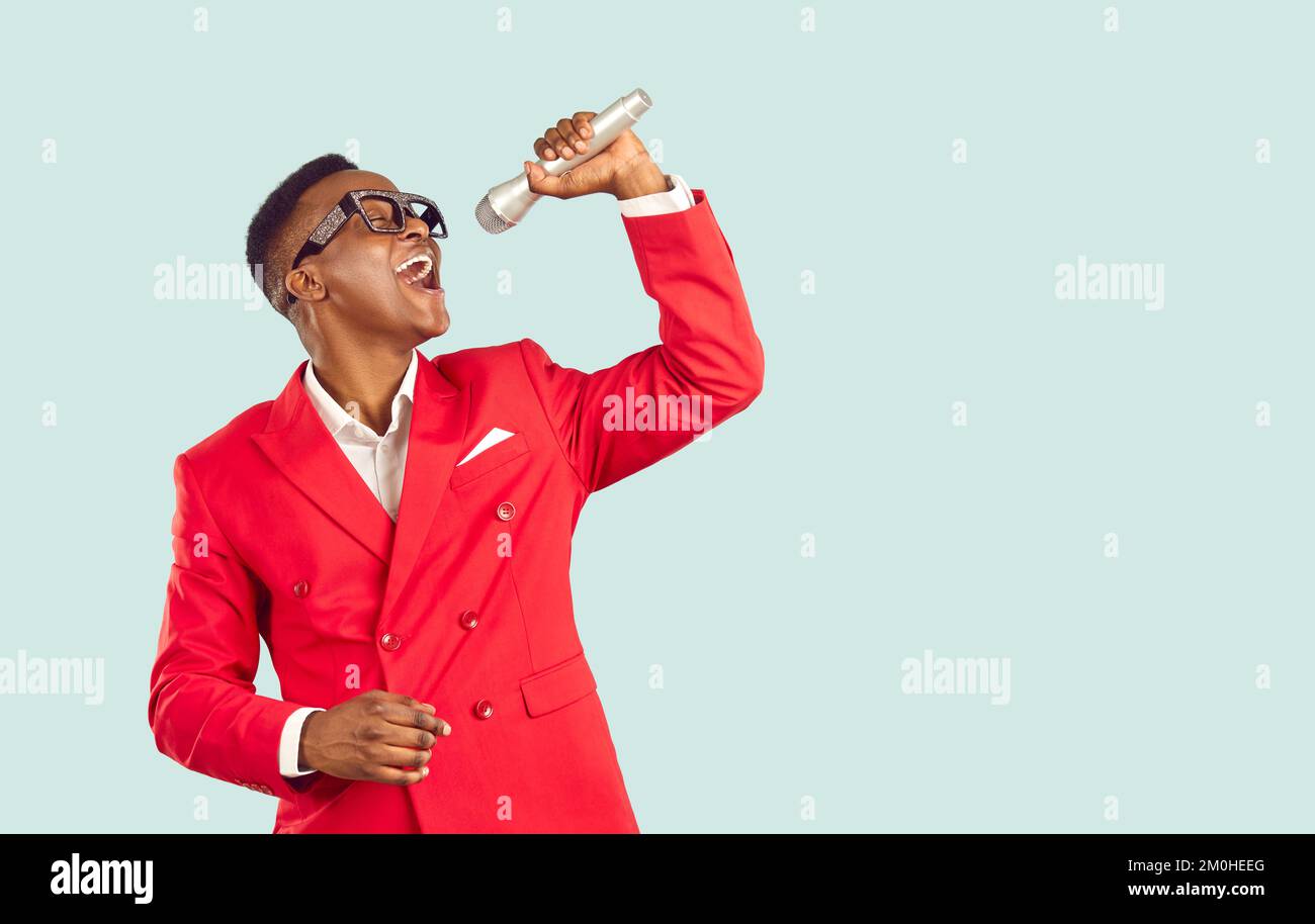 Cheerful trendy african american mc showman singing into microphone on ...