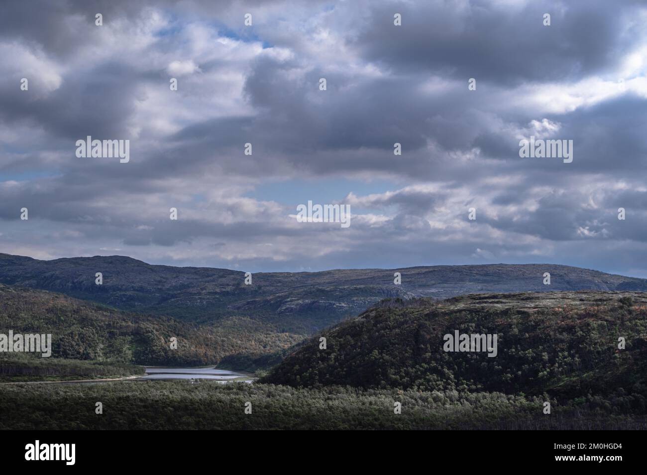 Marvelous scenery of forested mountains against cloudy skies. Sredny ...