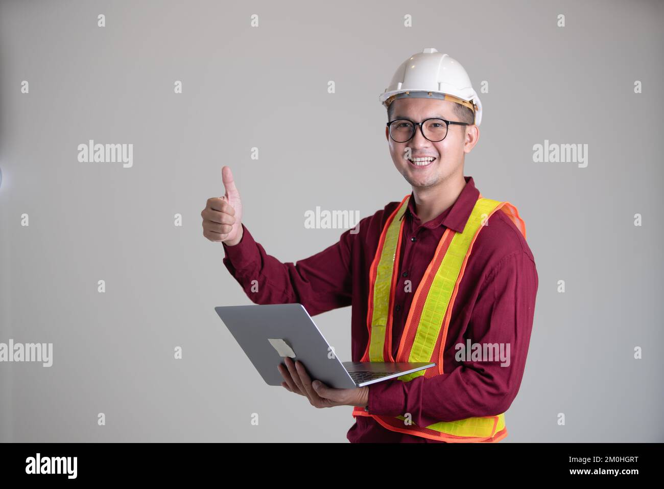 Thumbs up of engineering and holding a laptop Stock Photo - Alamy