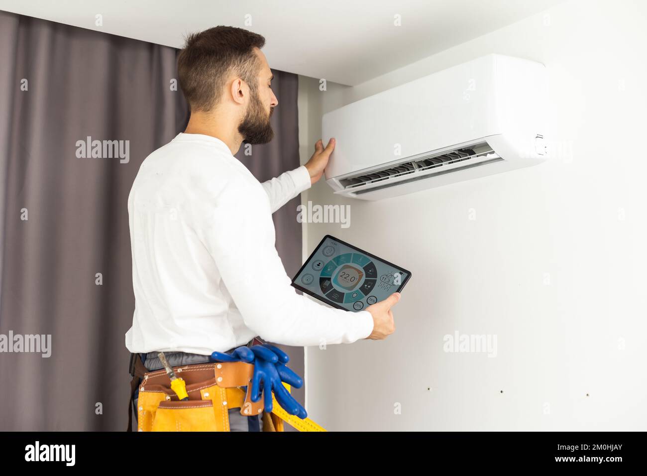 Technician repairing air conditioner on the wall Stock Photo - Alamy