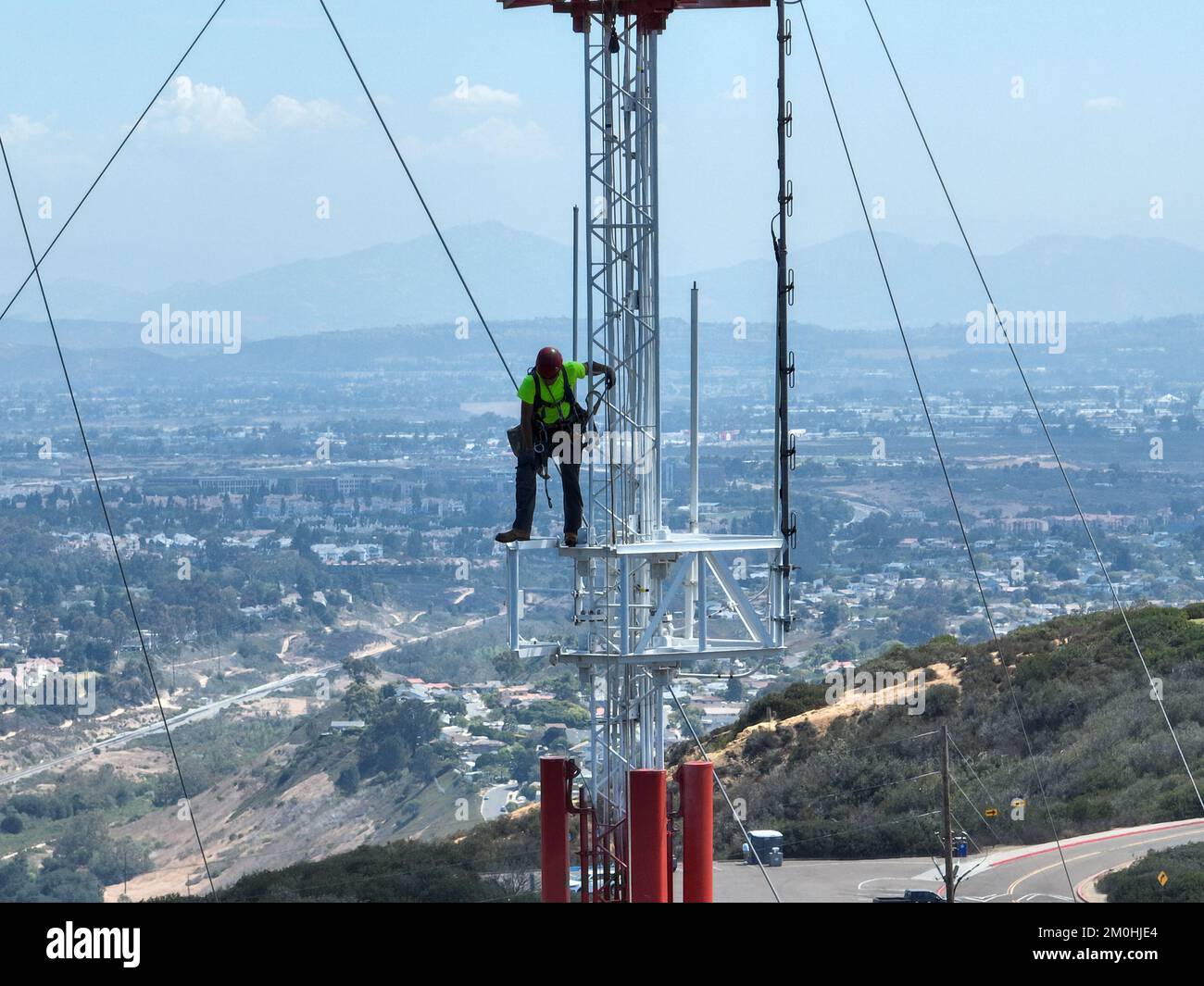 Engineer with safety equipment on high tower for working telecom ...