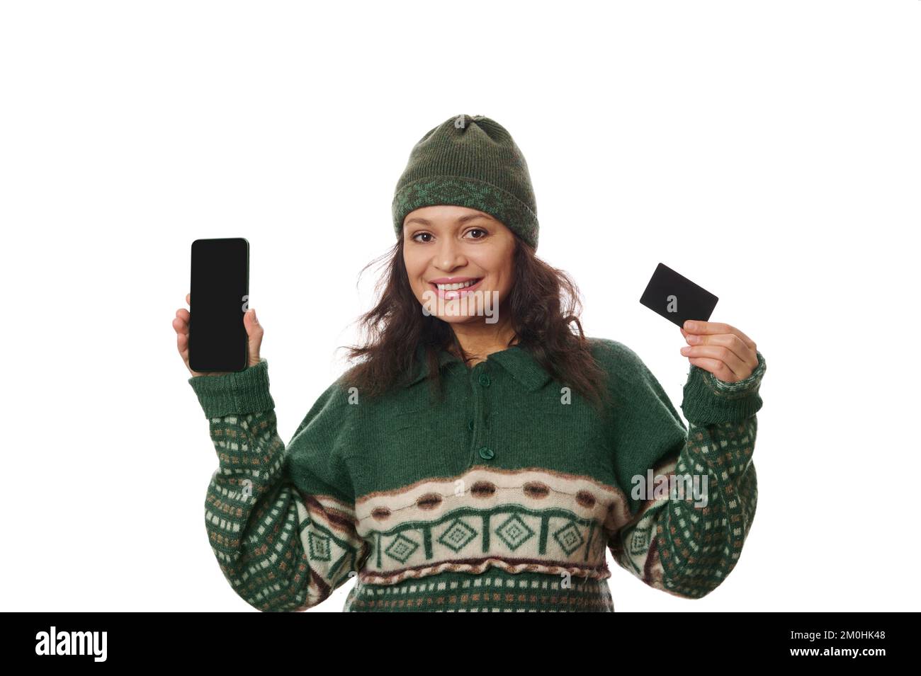 Pretty woman in warm woolen clothes, showing smartphone and blank ...