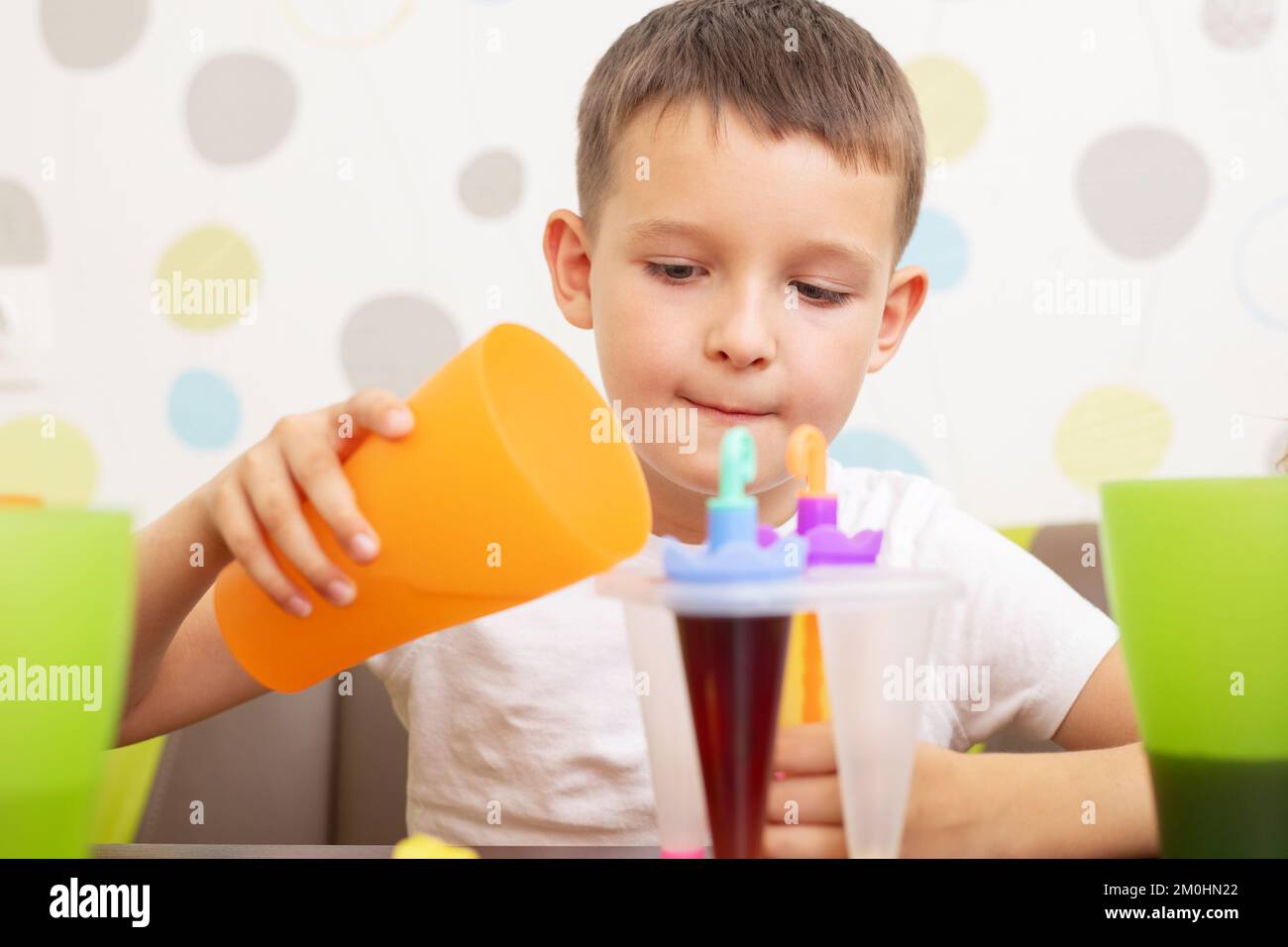 Child making ice cream from fruit juice on table at home Stock Photo ...