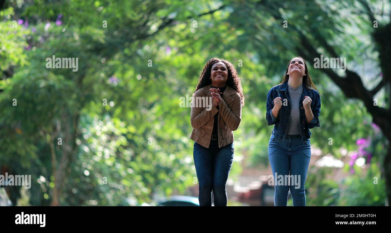 Excited two young women celebrating good news. Diverse girls dancing ...