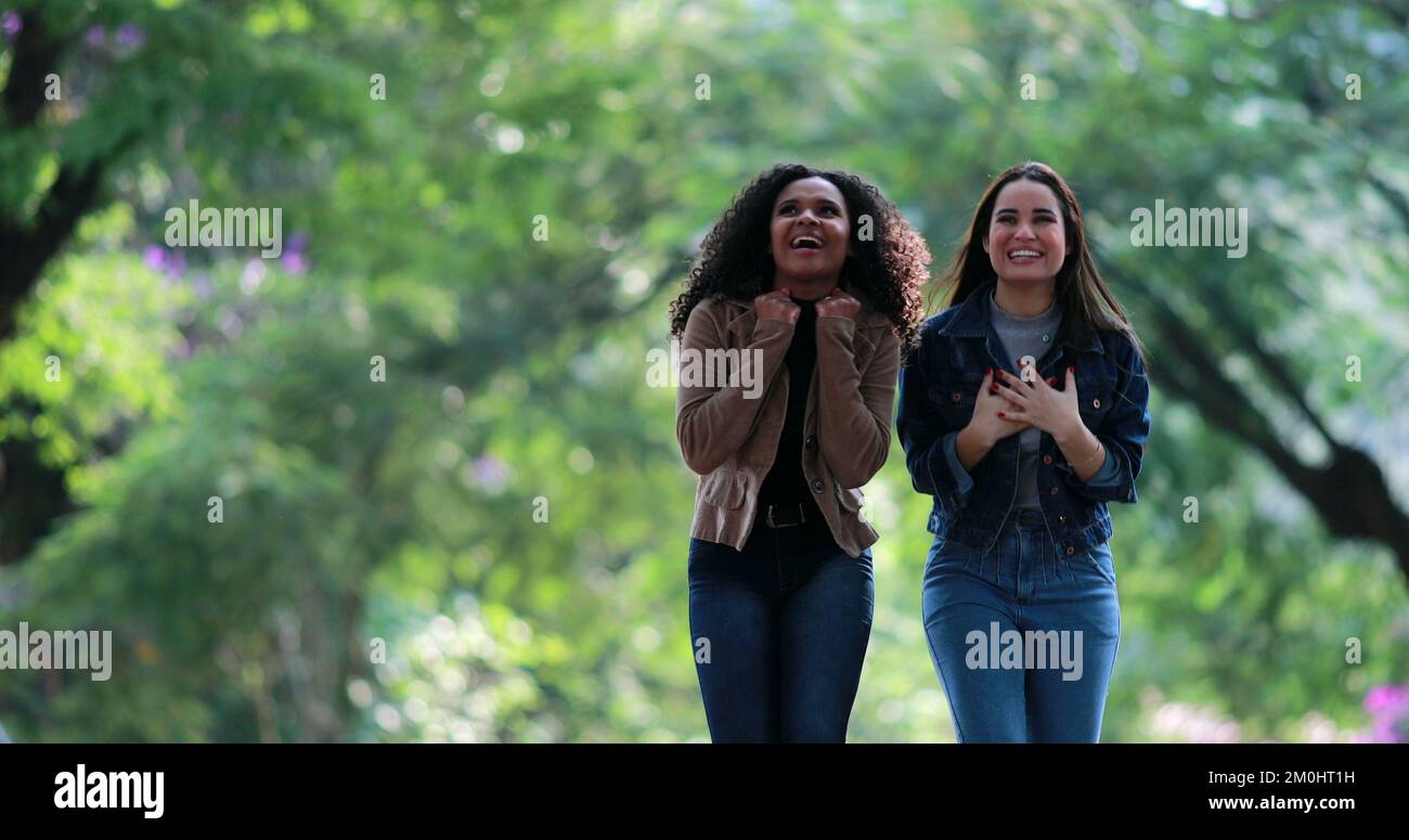 Excited two young women celebrating good news. Diverse girls dancing ...