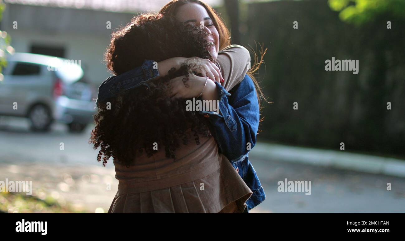 Happy reunion, two girlfriends embrace happy to see each other again ...