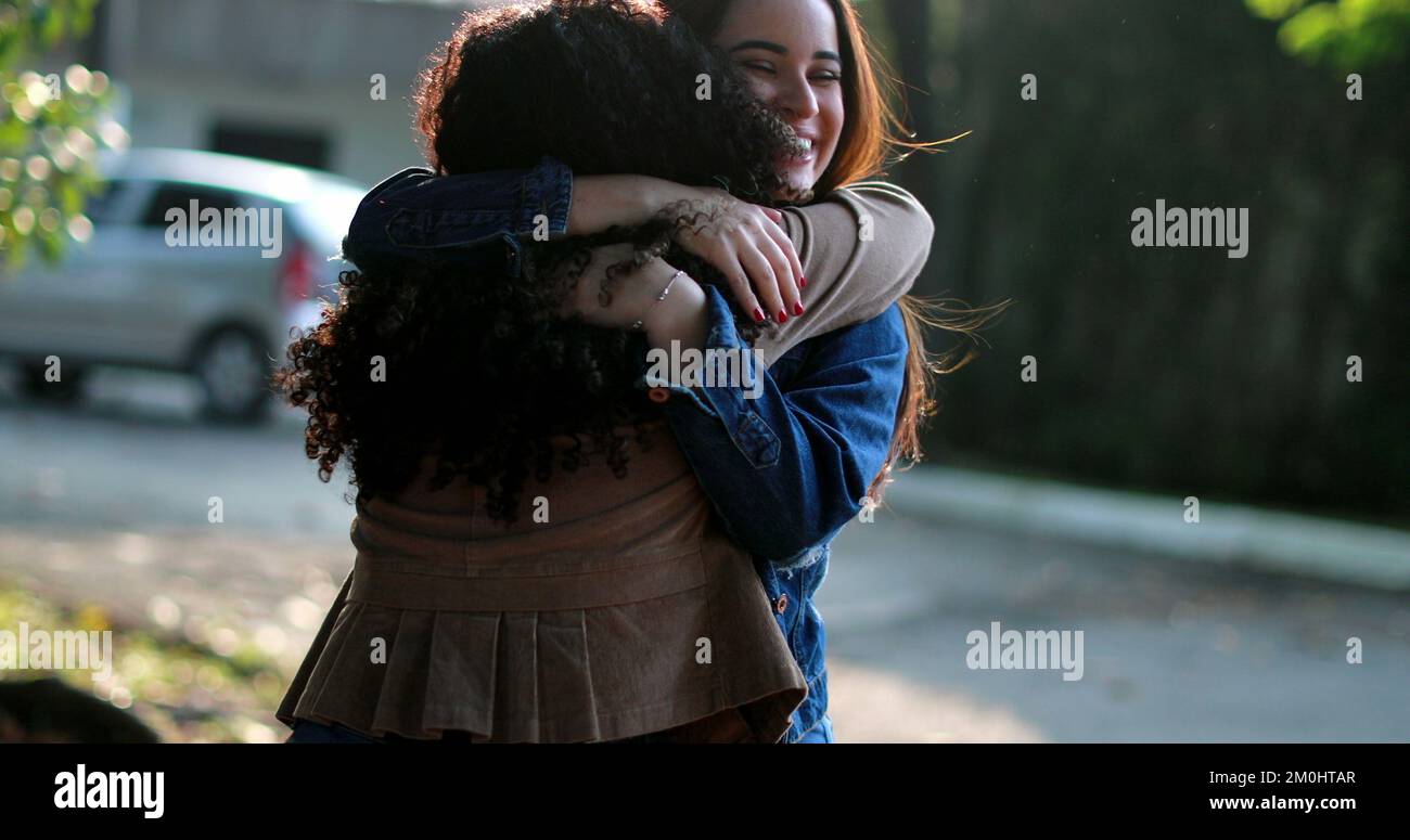 Happy reunion, two girlfriends embrace happy to see each other again ...