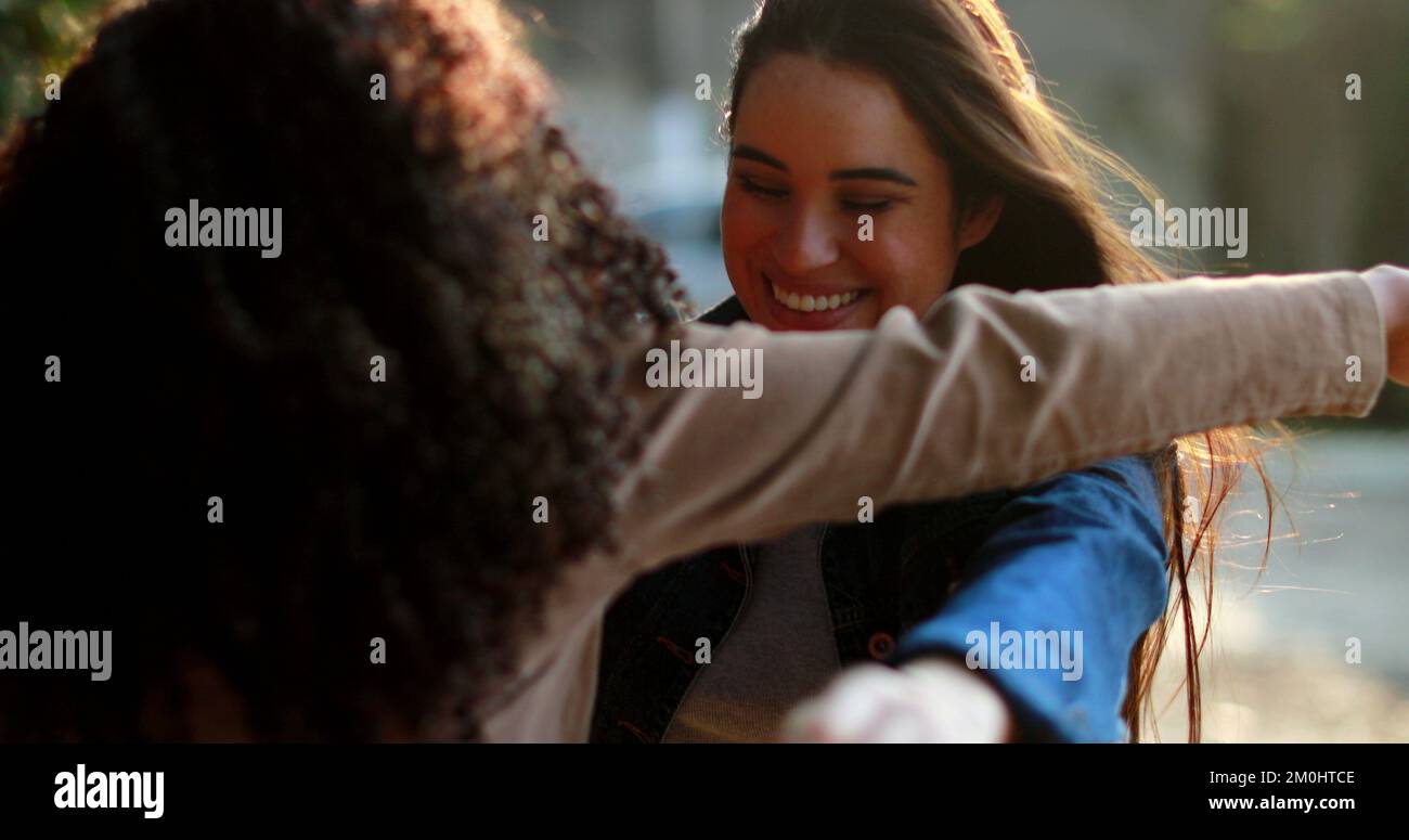 Happy reunion, two girlfriends embrace happy to see each other again ...