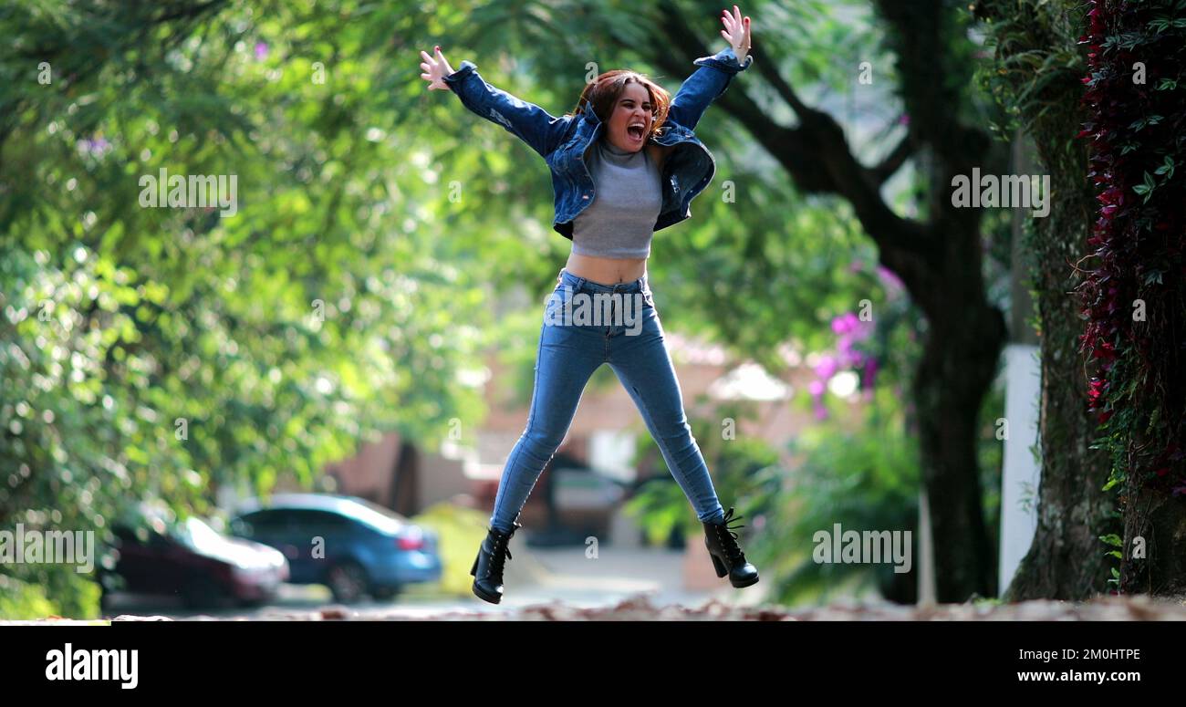 Fun person jumping with joy, young woman celebrating success jumps ...