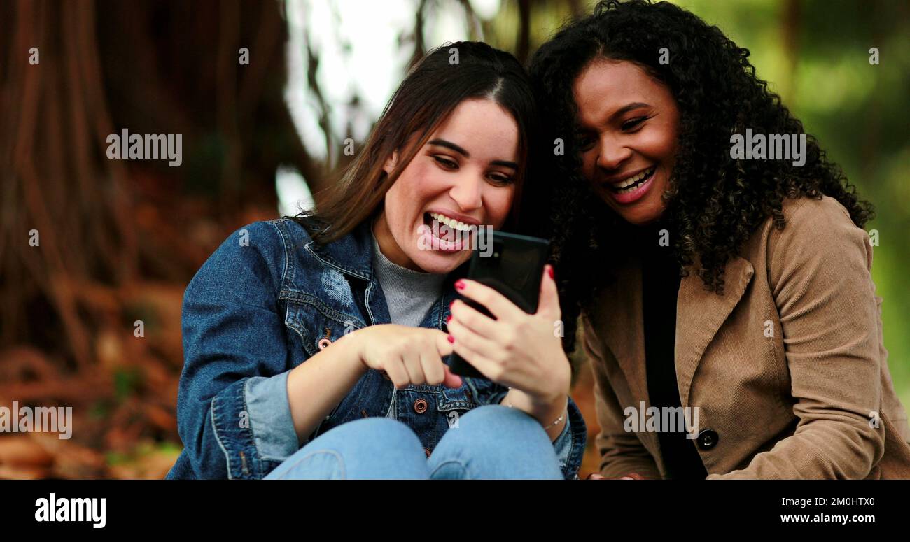 Diverse girls looking at cellphone screen. Woman calling friend to ...